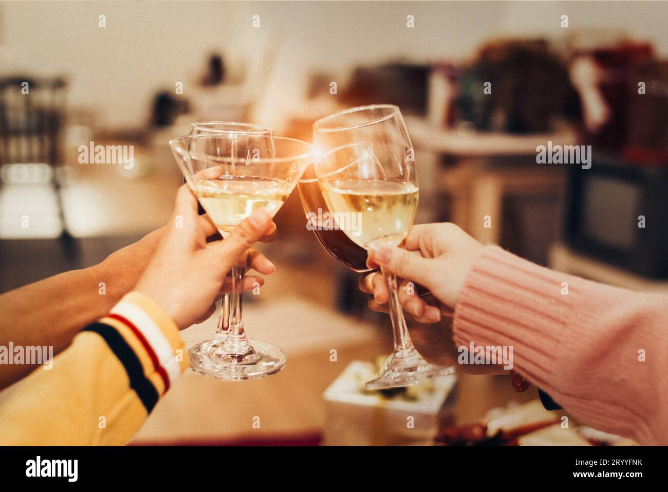 Hände von Menschen, die Neujahrsfeier zu Hause mit Weintrinkgläsern und ...