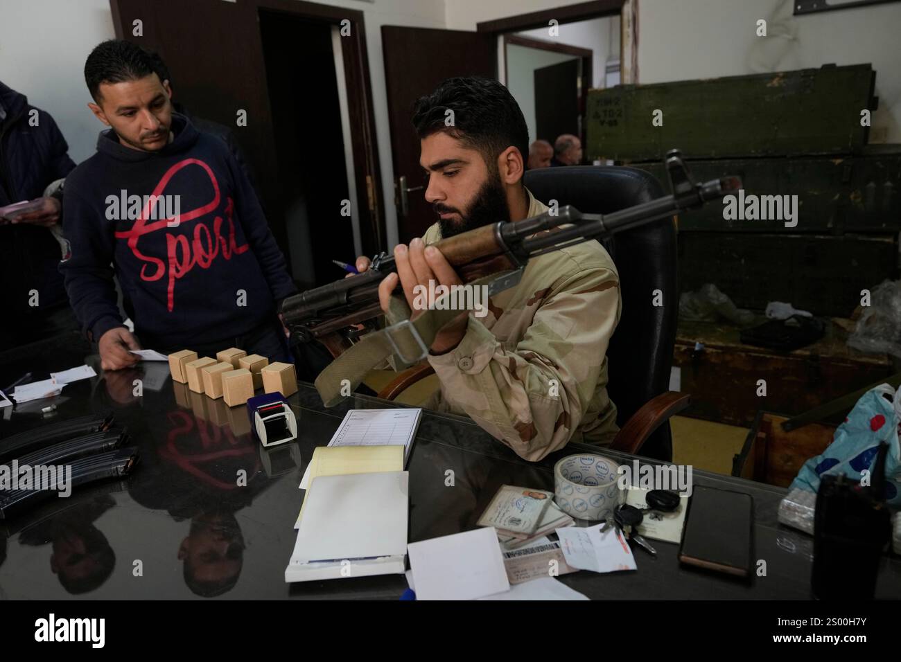 A Syrian fighter, right, receives an AK-47 from a member of the ousted ...