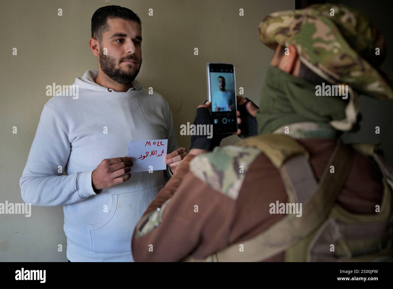 A Syrian fighter, right, takes a picture of a member of ousted Syrian ...