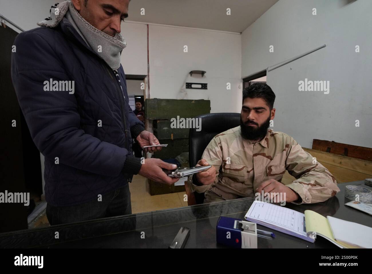 A Syrian fighter, right, receives a gun from a member of the ousted ...