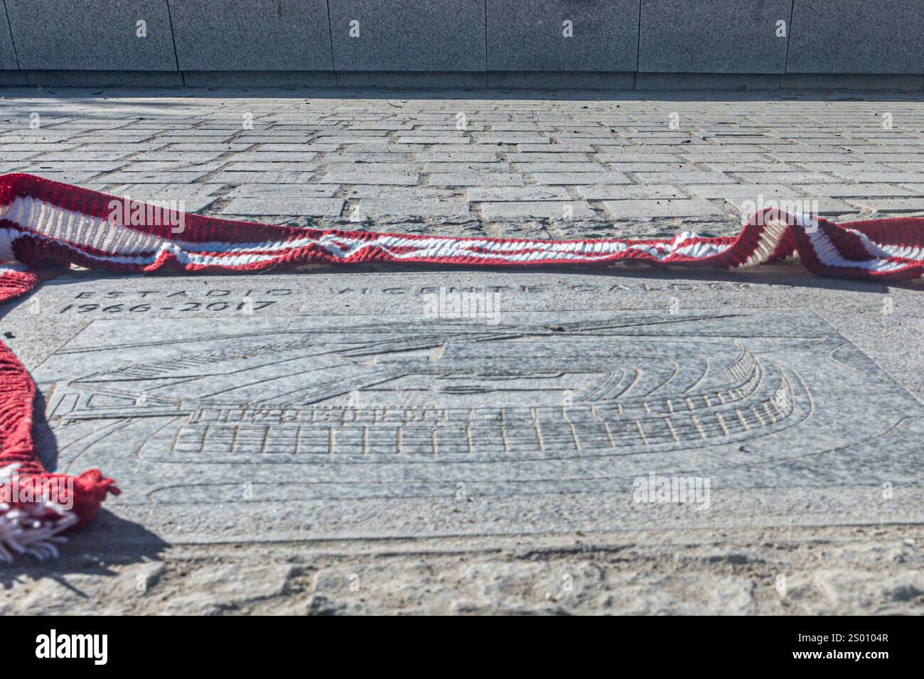 An Atletico Madrid scarf and jersey next to a slab with the silhouette ...