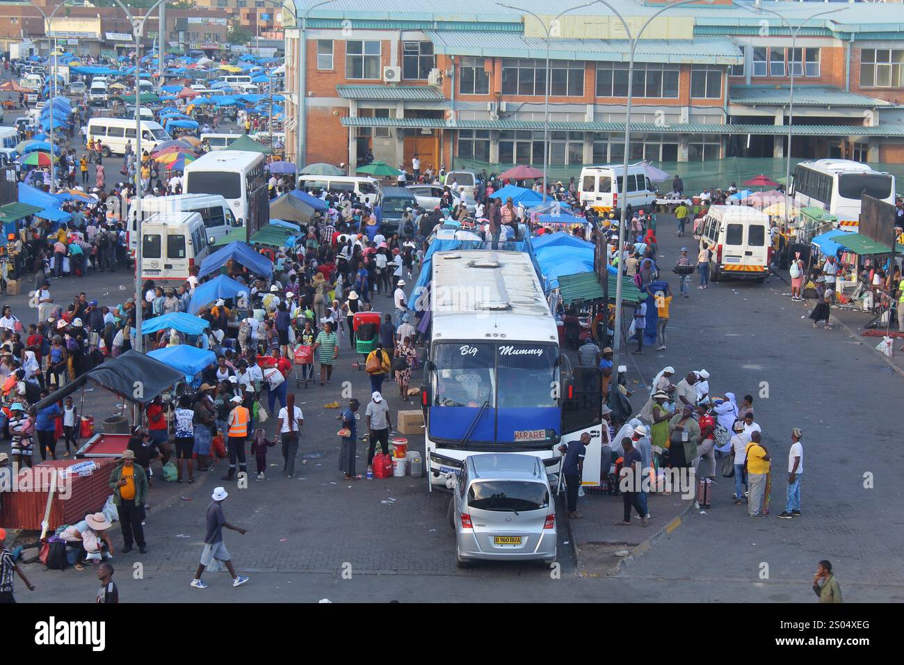 Francistown, Botsuana. Dezember 2024. Menschen und Fahrzeuge werden am ...