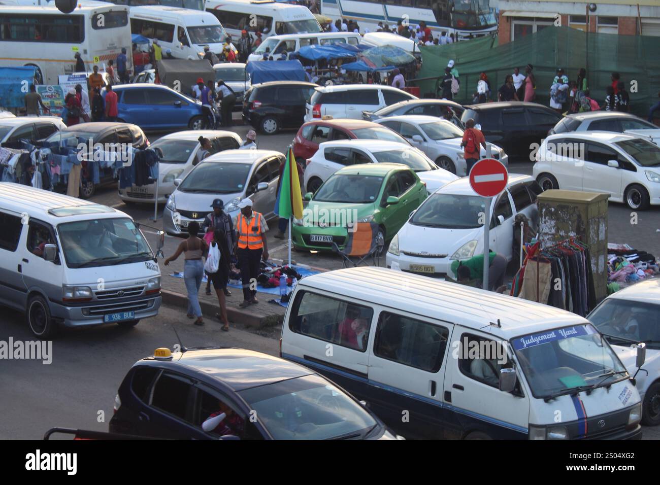 Francistown, Botsuana. Dezember 2024. Menschen und Fahrzeuge werden am ...