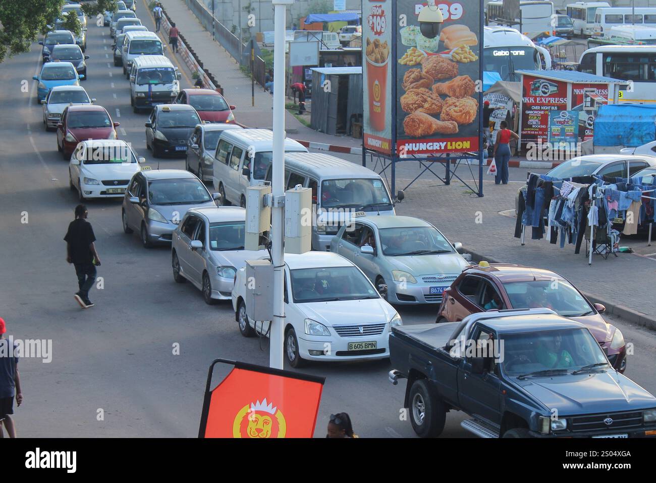 Francistown, Botsuana. Dezember 2024. Menschen und Fahrzeuge werden am ...