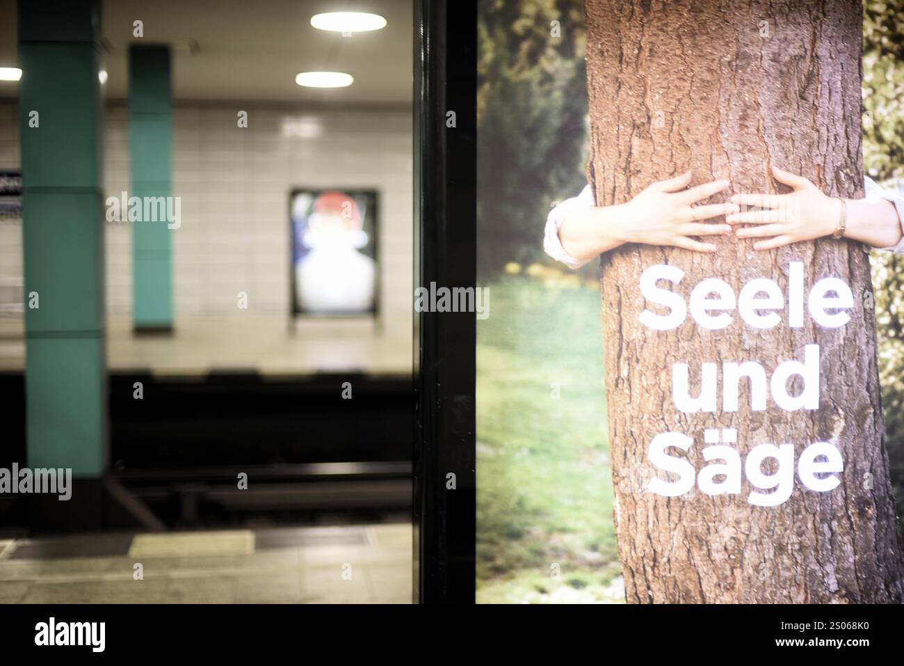 Auf einer Werbetafel am Bahnsteig S-Bahn ist ein Baum zu sehen, der ...