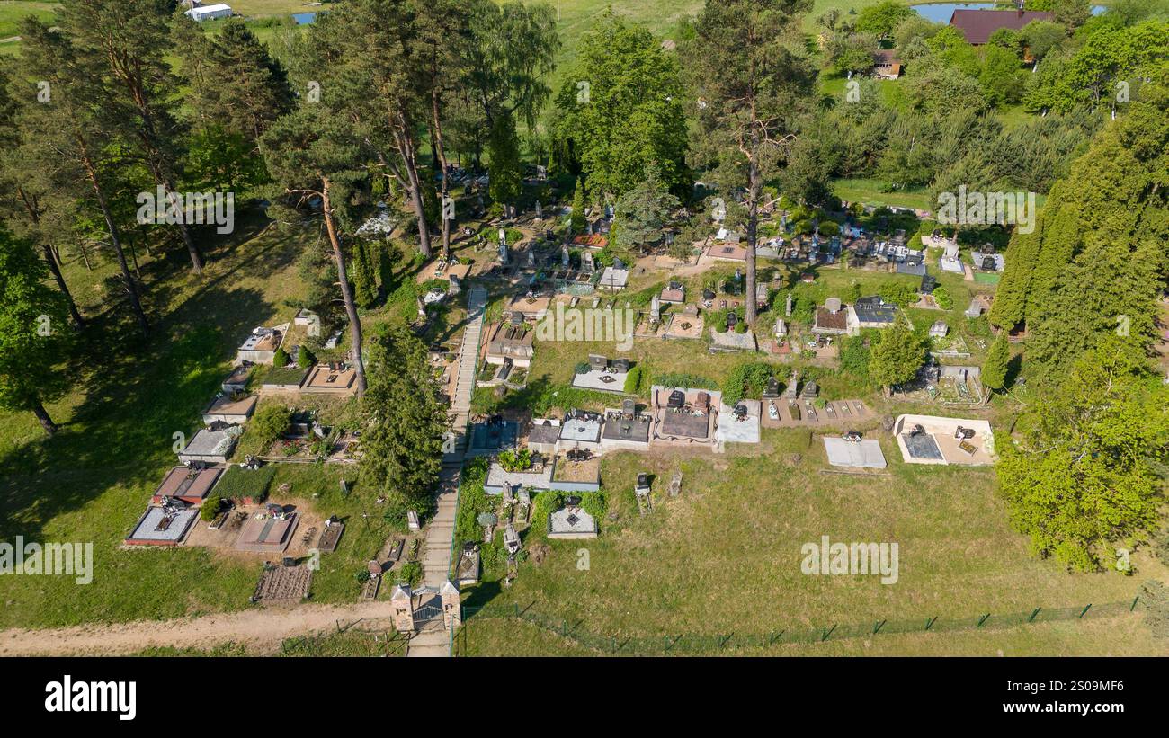 Blick aus der Vogelperspektive auf einen Friedhof, der von Bäumen und ...
