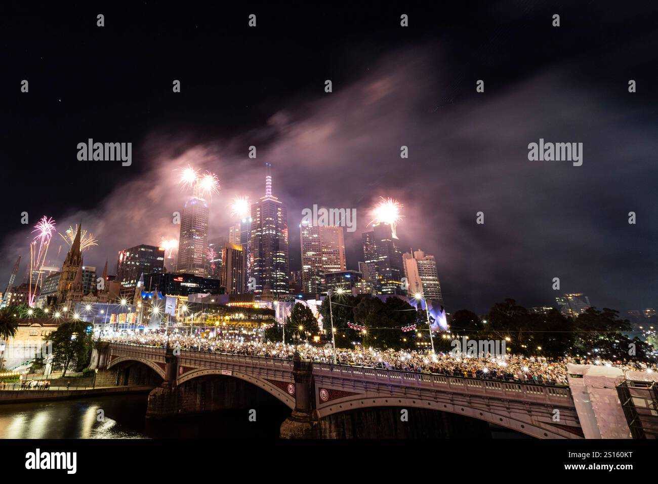 Ein Feuerwerk erleuchtet Melbournes Stadtbild. Die Flinders Street Station und der Yarra River ...