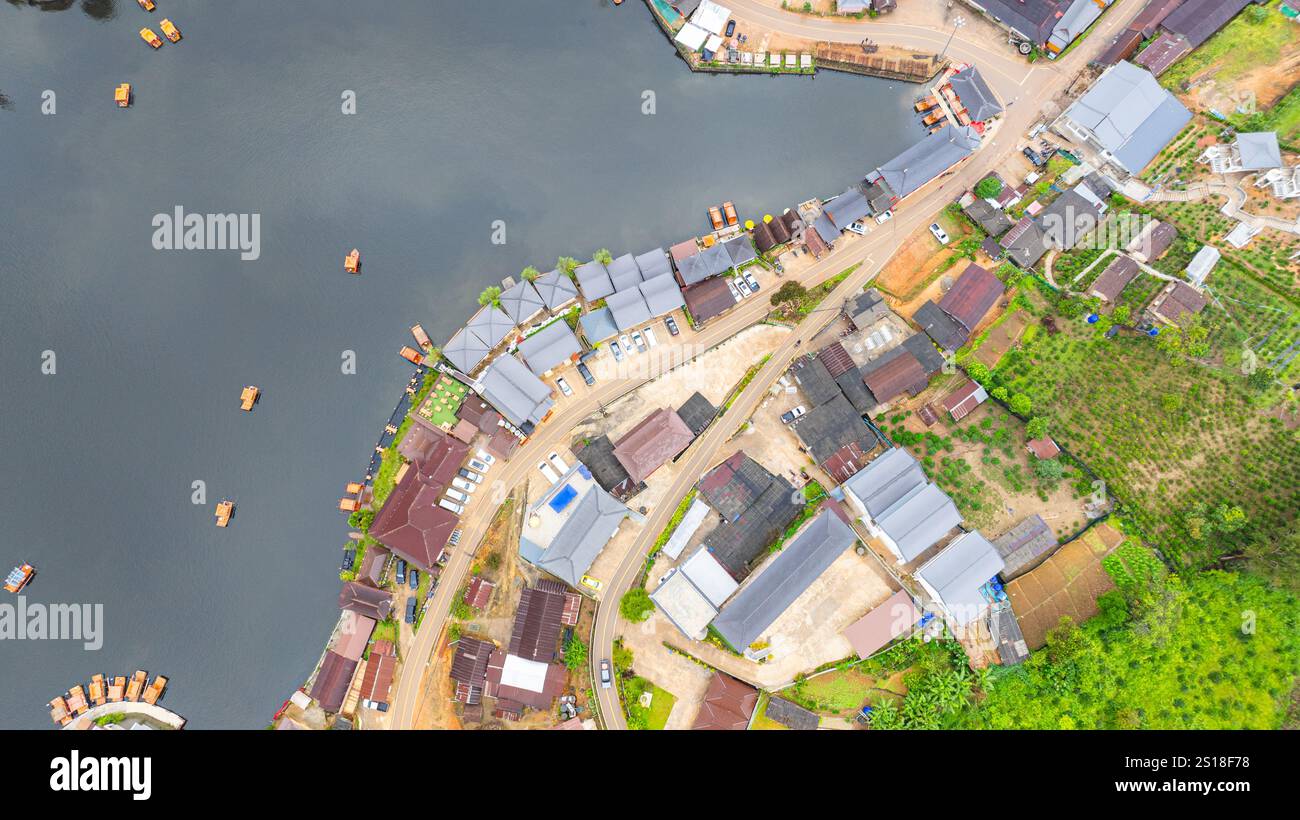 Blick von oben auf ein Dorf am See, mit einer Mischung aus rustikaler ...