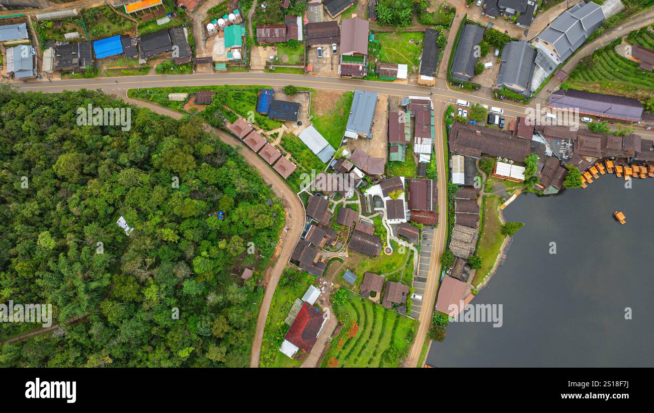 Blick von oben auf ein Dorf am See, mit einer Mischung aus rustikaler ...