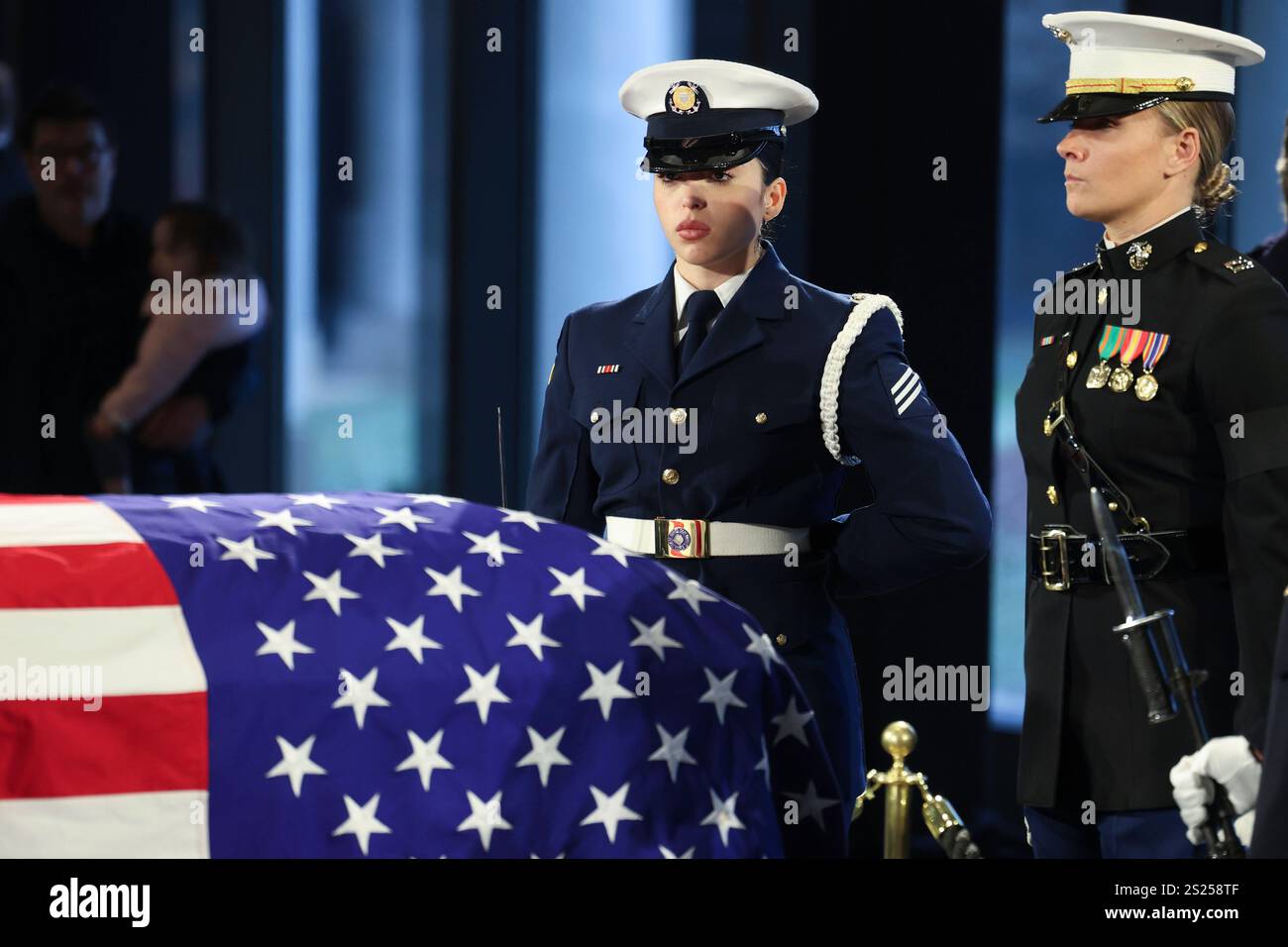 Members of the joint services military honor guard stand by the casket bearing the remains of ...