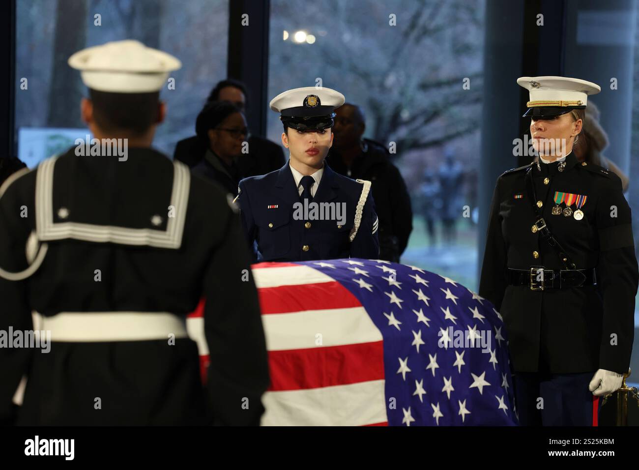 Members of the joint services military honor guard stand by the casket bearing the remains of ...