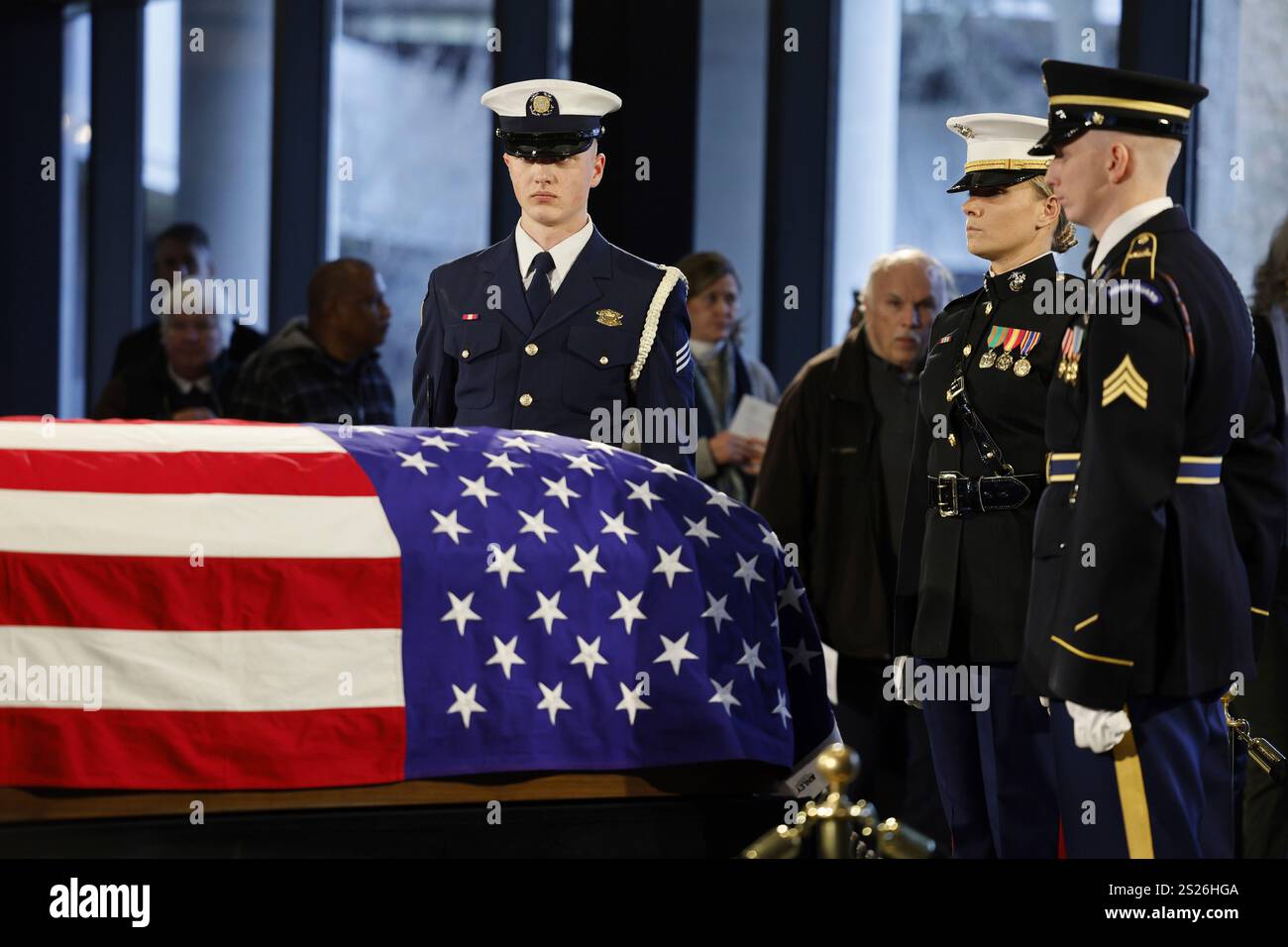 Members of the joint services military honor guard stand at attention as mourners view the ...
