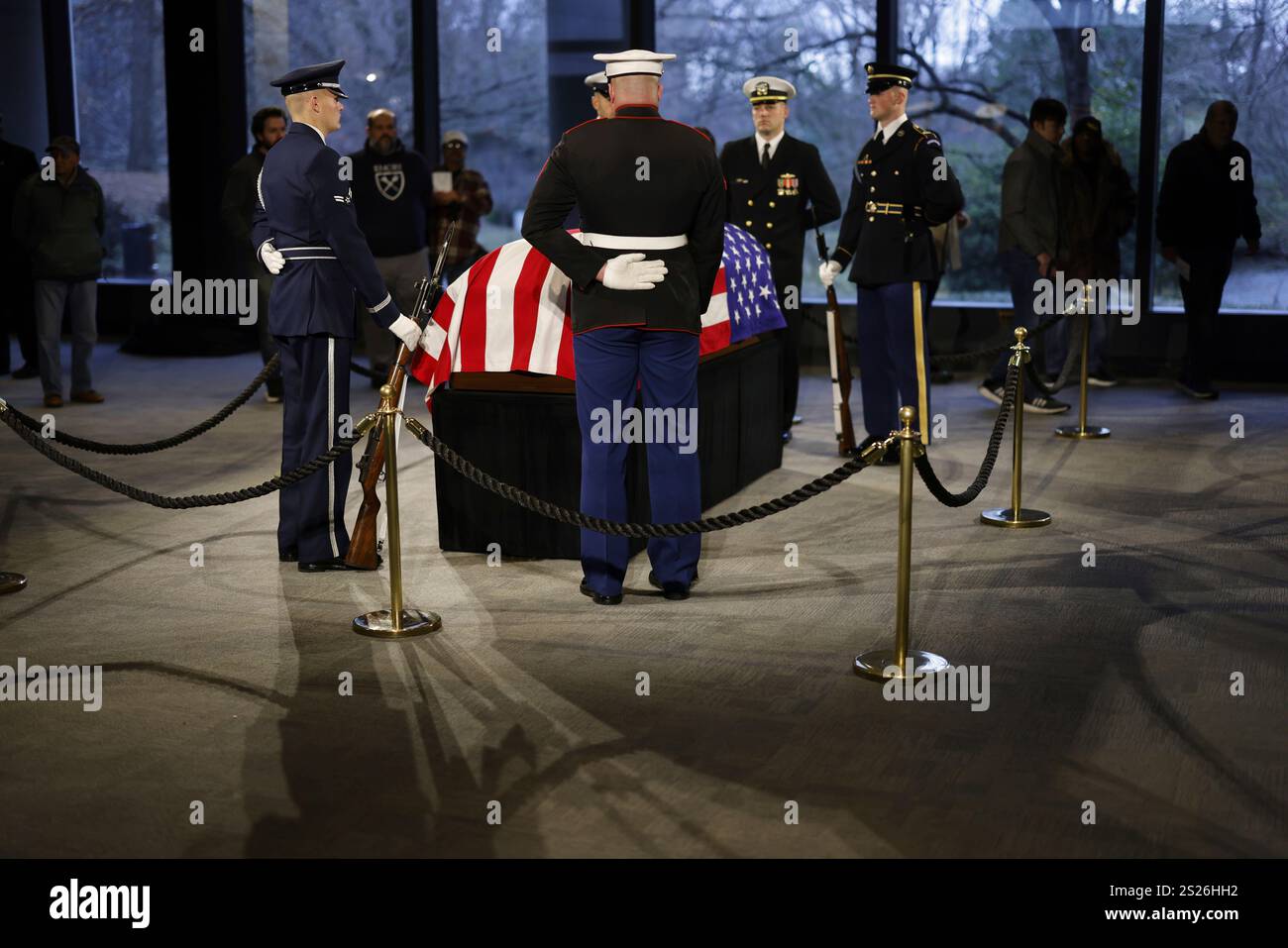 Members of the joint services military honor guard stand at attention as mourners view the ...