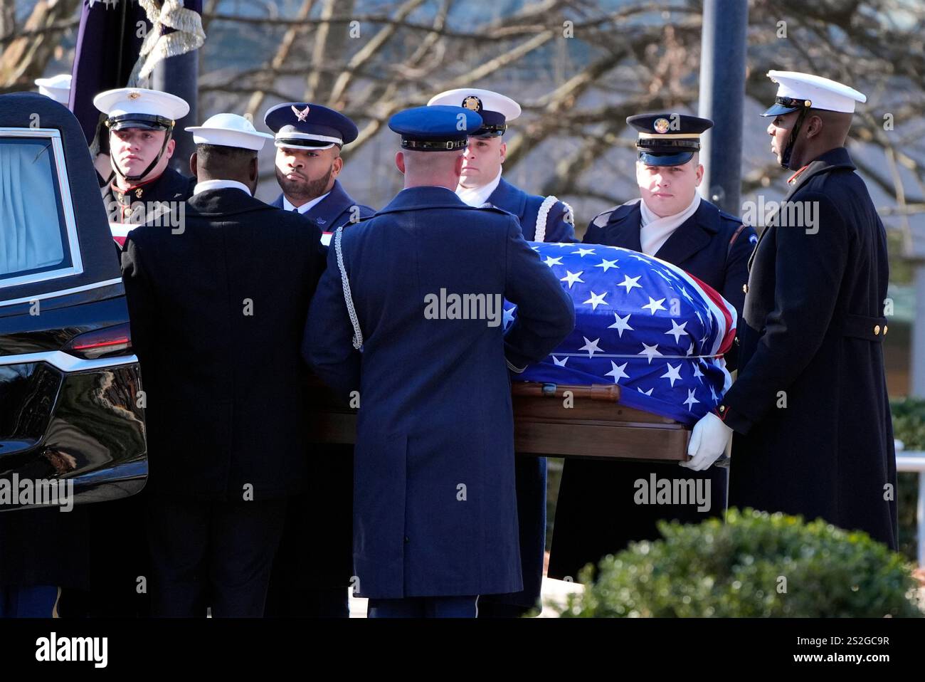 The casket of former President Jimmy Carter is placed into the hearse ...