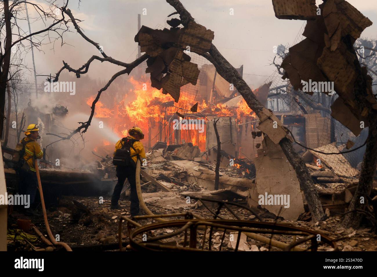 Firefighters battle the Palisades Fire as it burns a structure in the ...