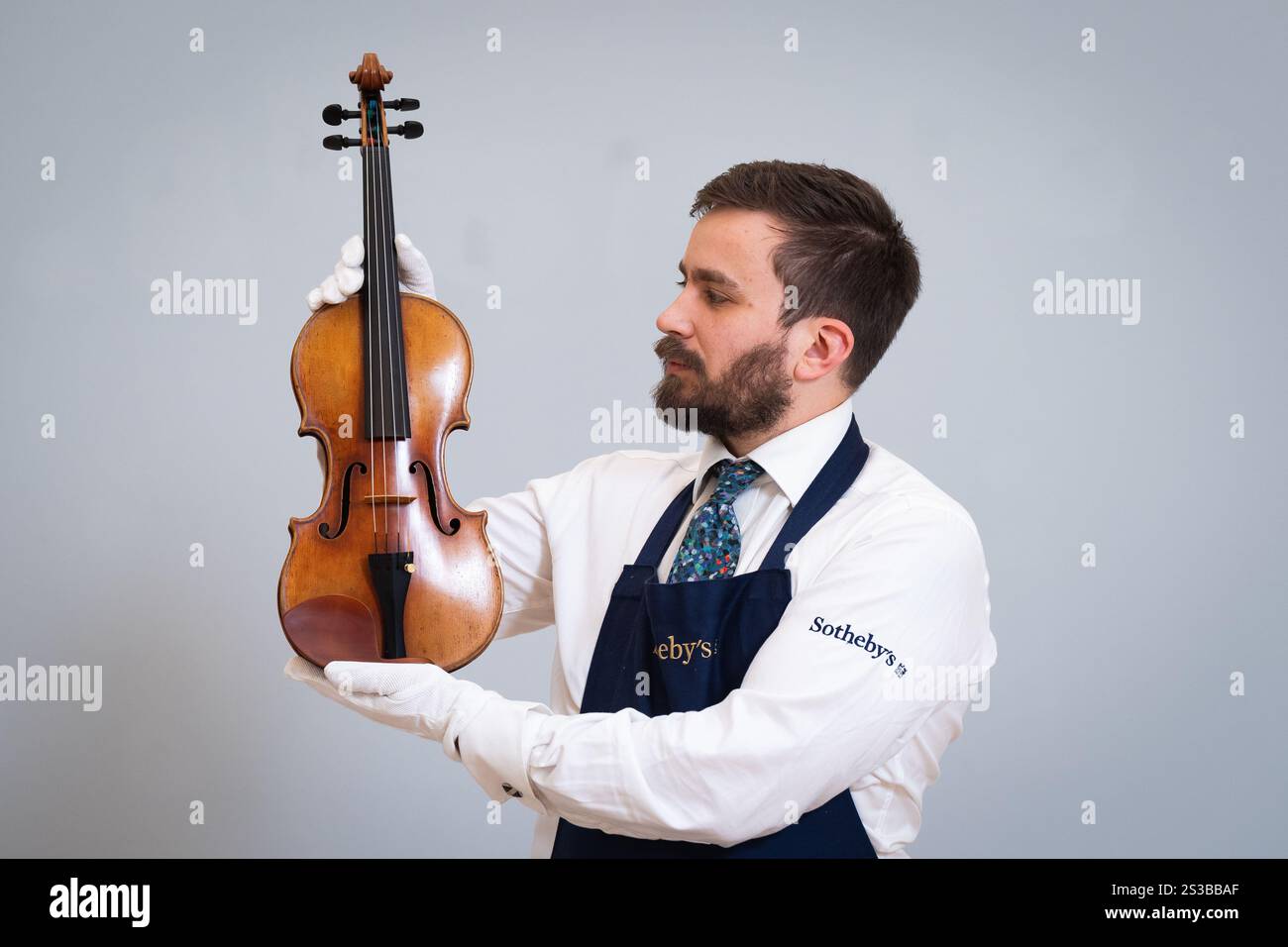 Ein Techniker von Sotheby's hält die Joachim-Ma Stradivarius Violine bei Sotheby's in London ...