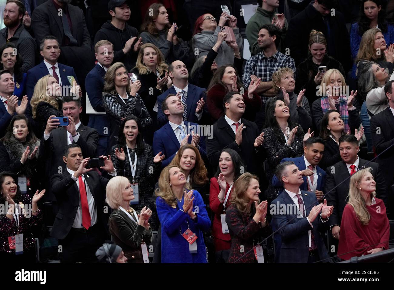 People react as they watch a big screen from the arena site of an ...