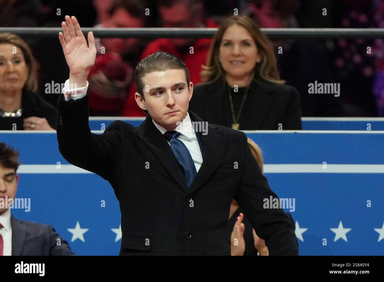 Barron Trump waves at an indoor Presidential Inauguration parade event ...
