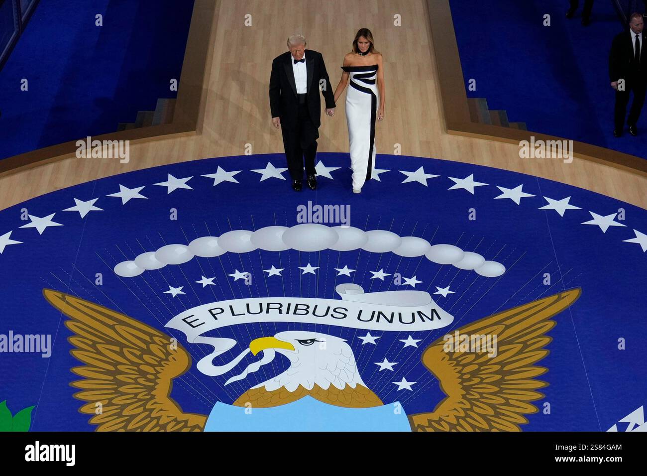 President Donald Trump, left, and first lady Melania Trump walk to the stage to dance at the ...