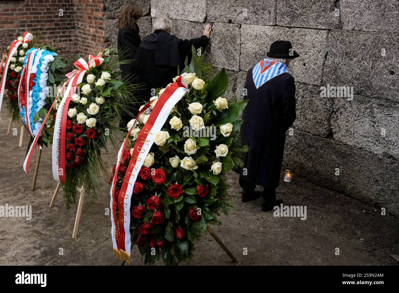 A survivor stands after placing a candle to the Death Wall at the ...