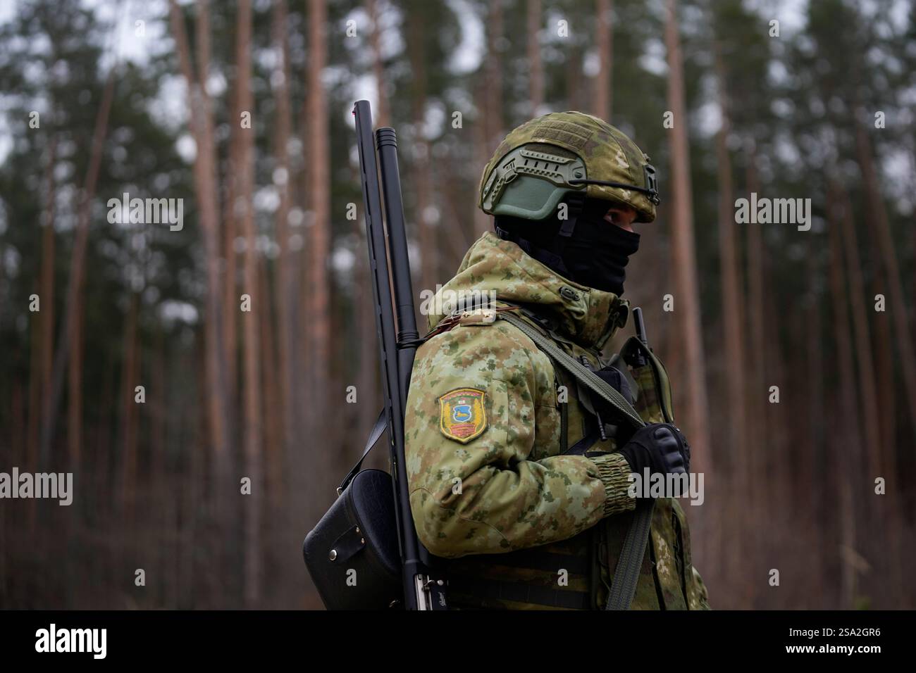 A Belarusian border guard inspects an area between Belarusian border ...