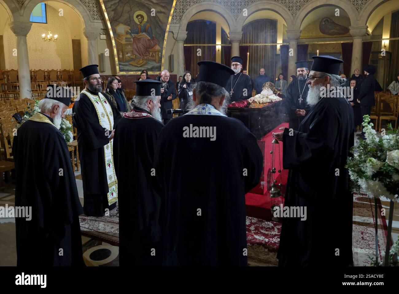 Greek Orthodox priests stand next to the casket of the late Archbishop ...