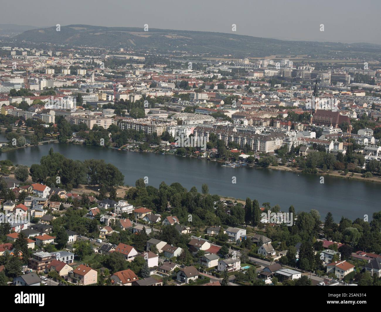 Blick auf eine Stadt am Fluss, umgeben von Hügeln und Wohngebieten ...