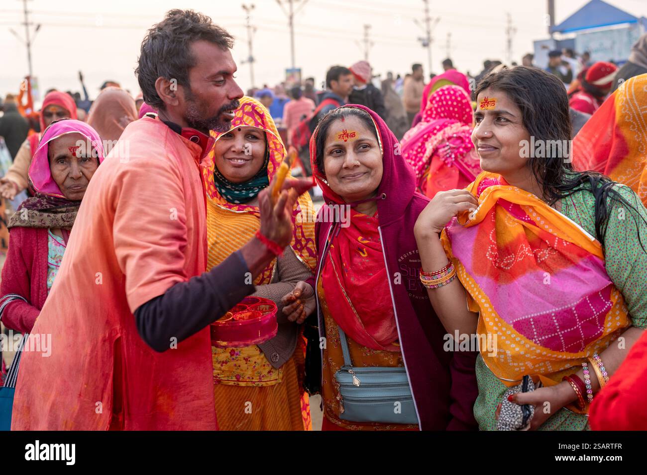 Mukesh Giri puts a sacred mark on a Hindu devotee's forehead at the confluence of the Ganges ...