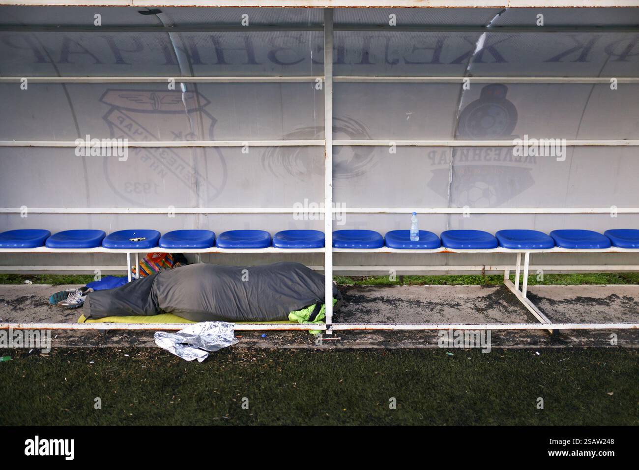 A student sleeps under soccer stadium bench as he attends a protest ...