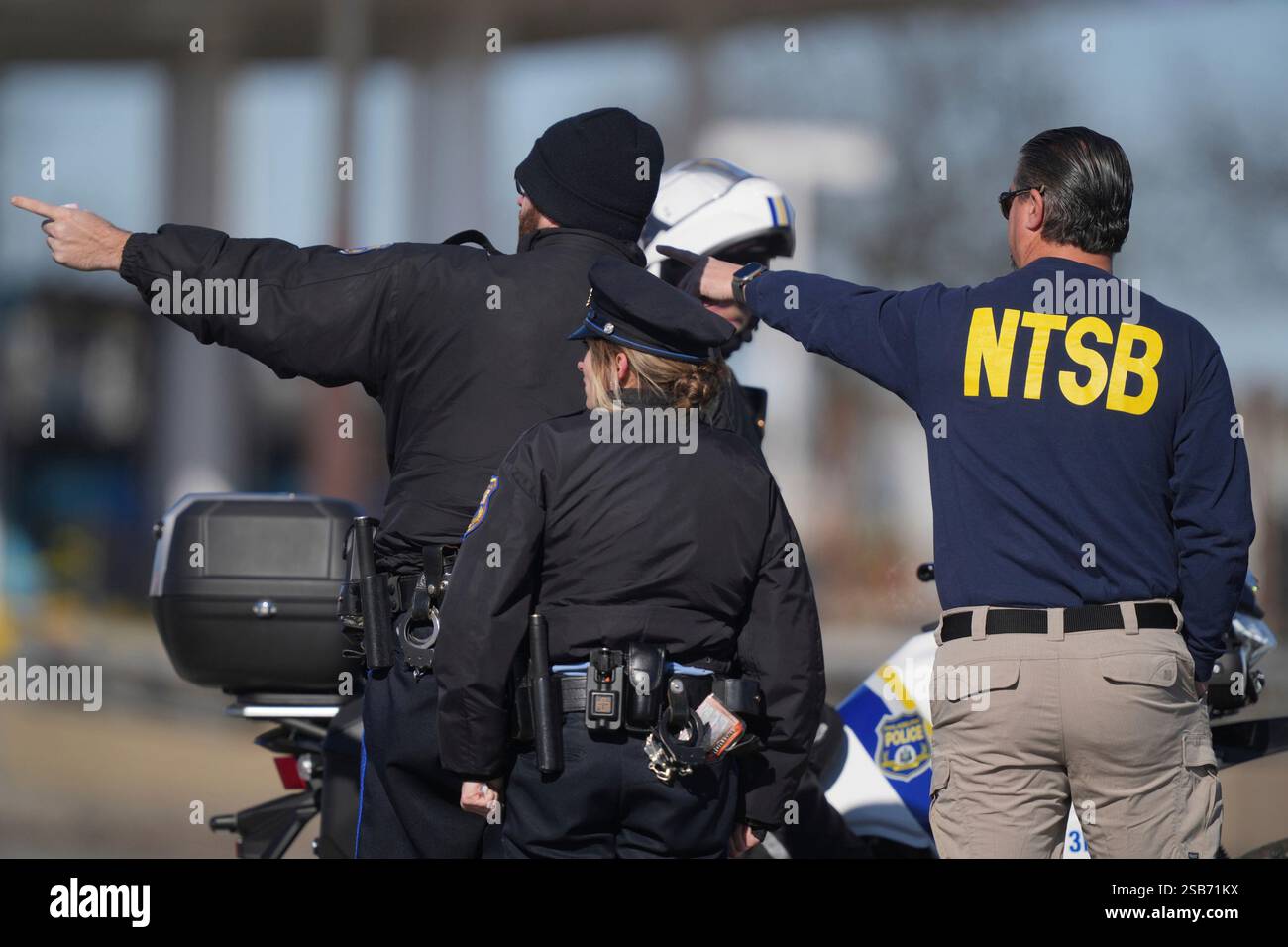 A member of the NTSB talks to Philadelphia Police officers near the ...