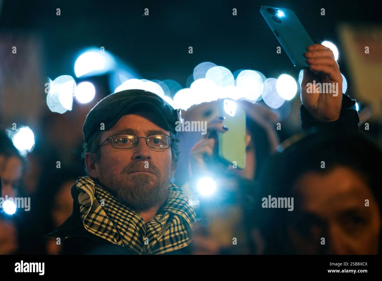 People hold up their mobile phone lights as tens of thousands gather ...