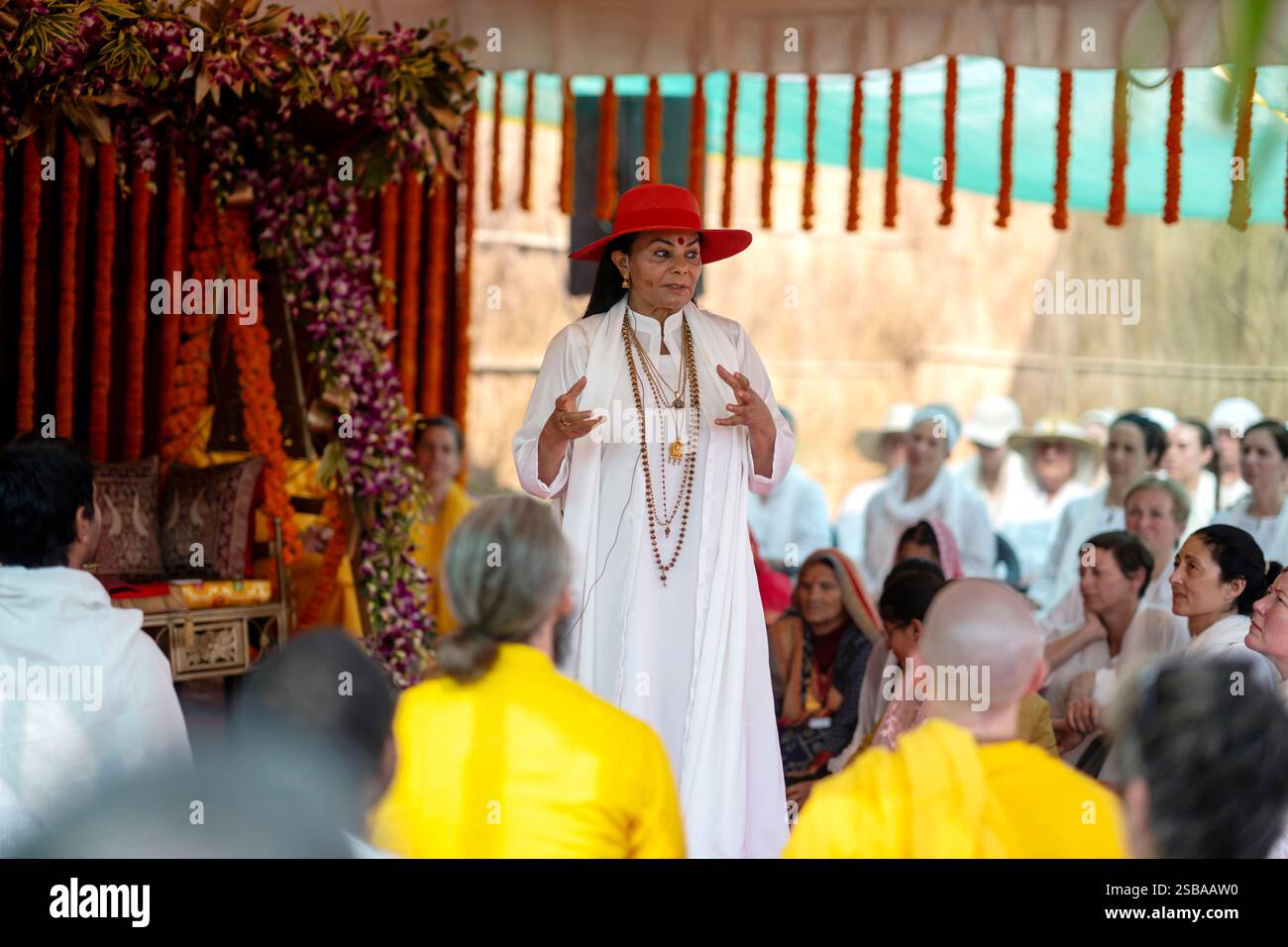 Devotees sit on ground and listen to Hindu holy woman Sai Maa during a ...