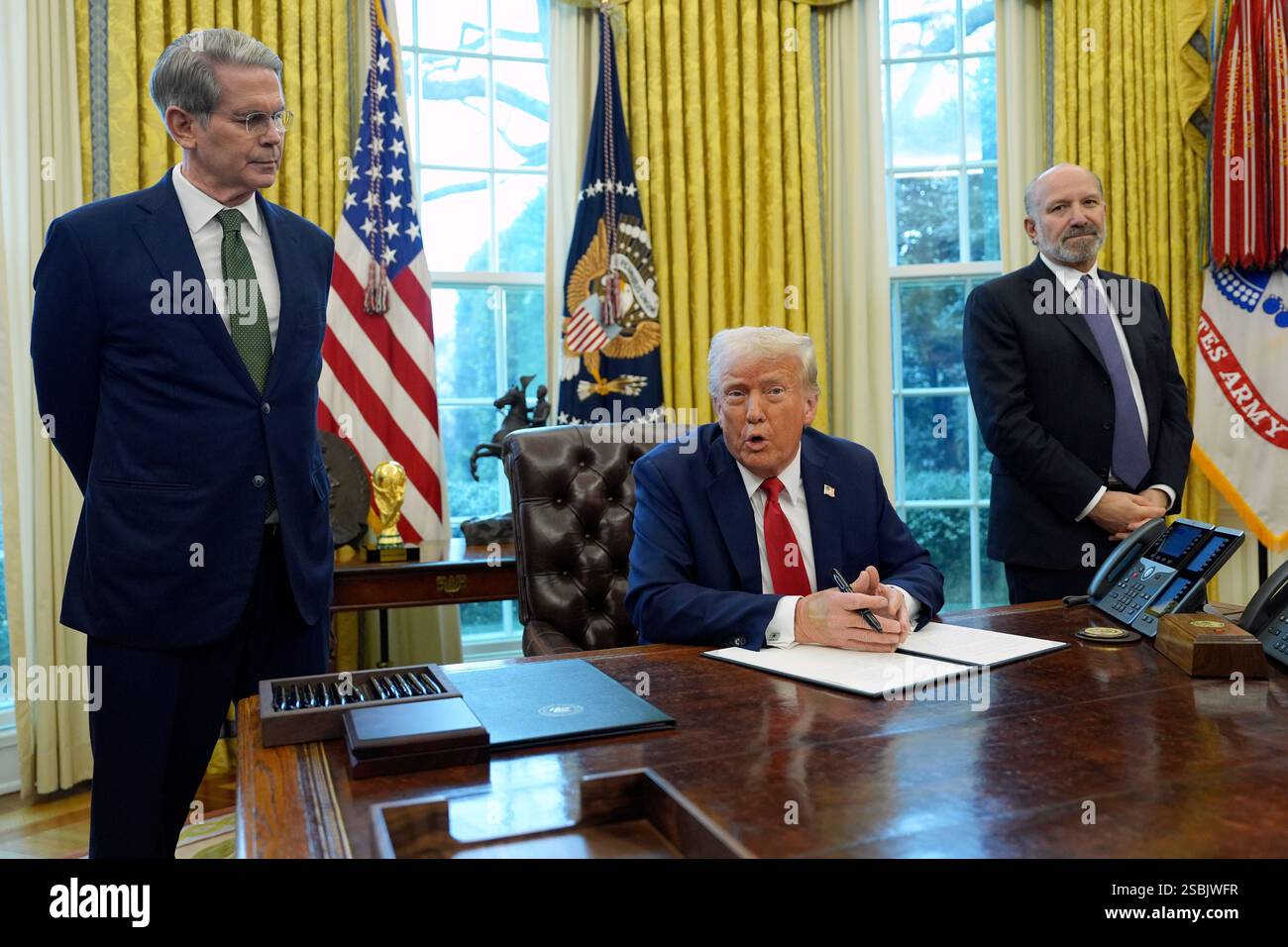 President Donald Trump speaks as Treasury Secretary Scott Bessent, left ...