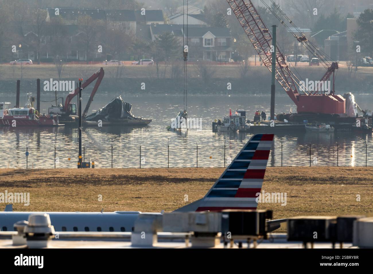 Salvage crews lift a piece of wreckage from the water at the site in the Potomac River of a mid ...
