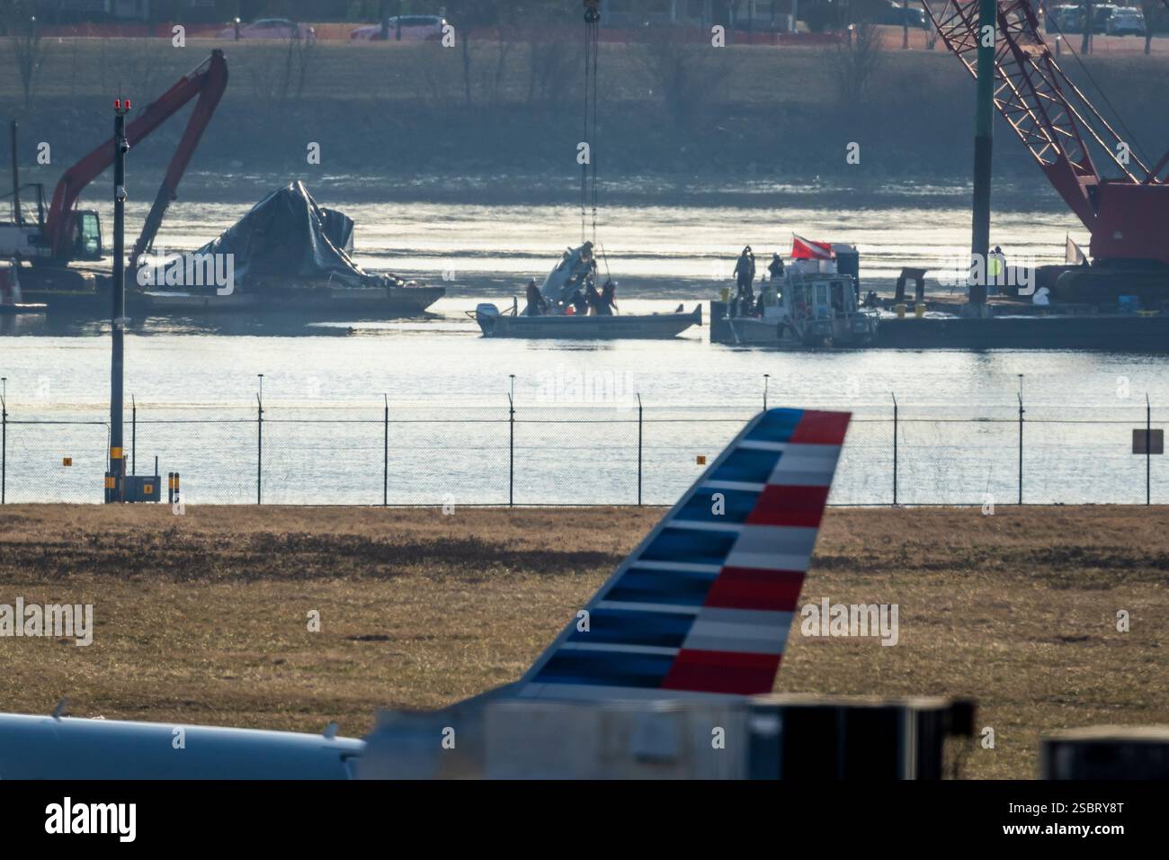Salvage crews lift a piece of wreckage from the water at the site in the Potomac River of a mid ...