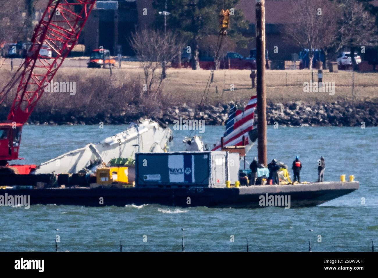 Parts of a plane are lifted from the water near the wreckage site in ...