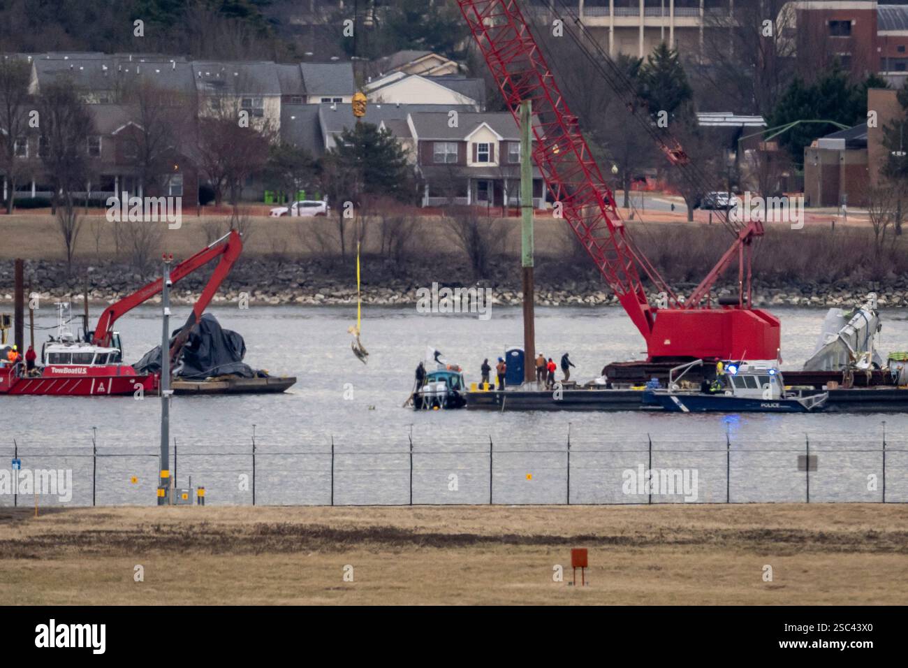 Salvage crews lift a piece of wreckage from the water, near the wreckage site in the Potomac ...