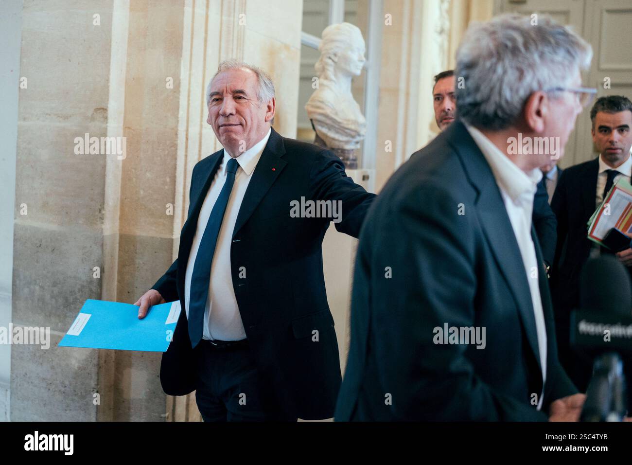 Der französische Premierminister Francois Bayrou klopft Eric Coquerel vor einer Abstimmung über ...