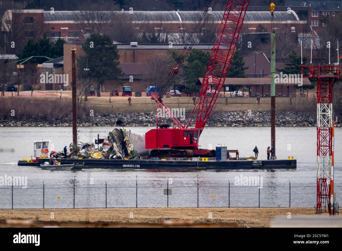 A salvage vessel carrying wreckage moves from the site in the Potomac ...