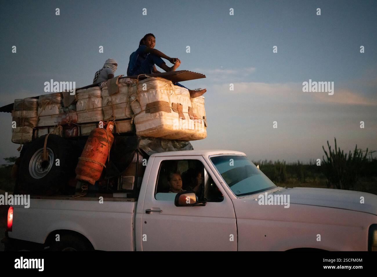 A family, of the Wayuu Indigenous group, carry supplies in a vehicle ...