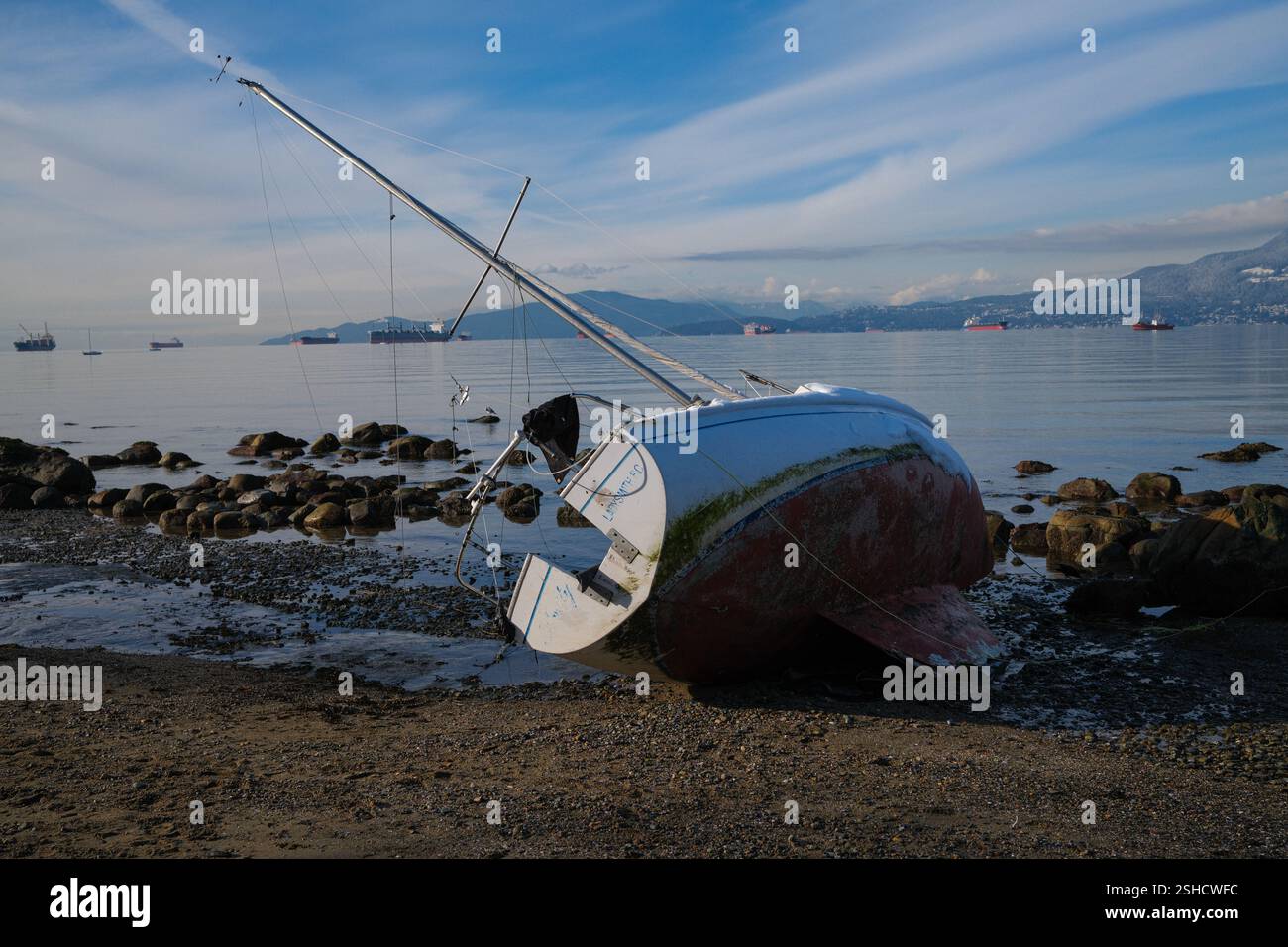 Ein verlassenes Boot, das am Kitsilano Beach in Vancouver, BC, an Land ...