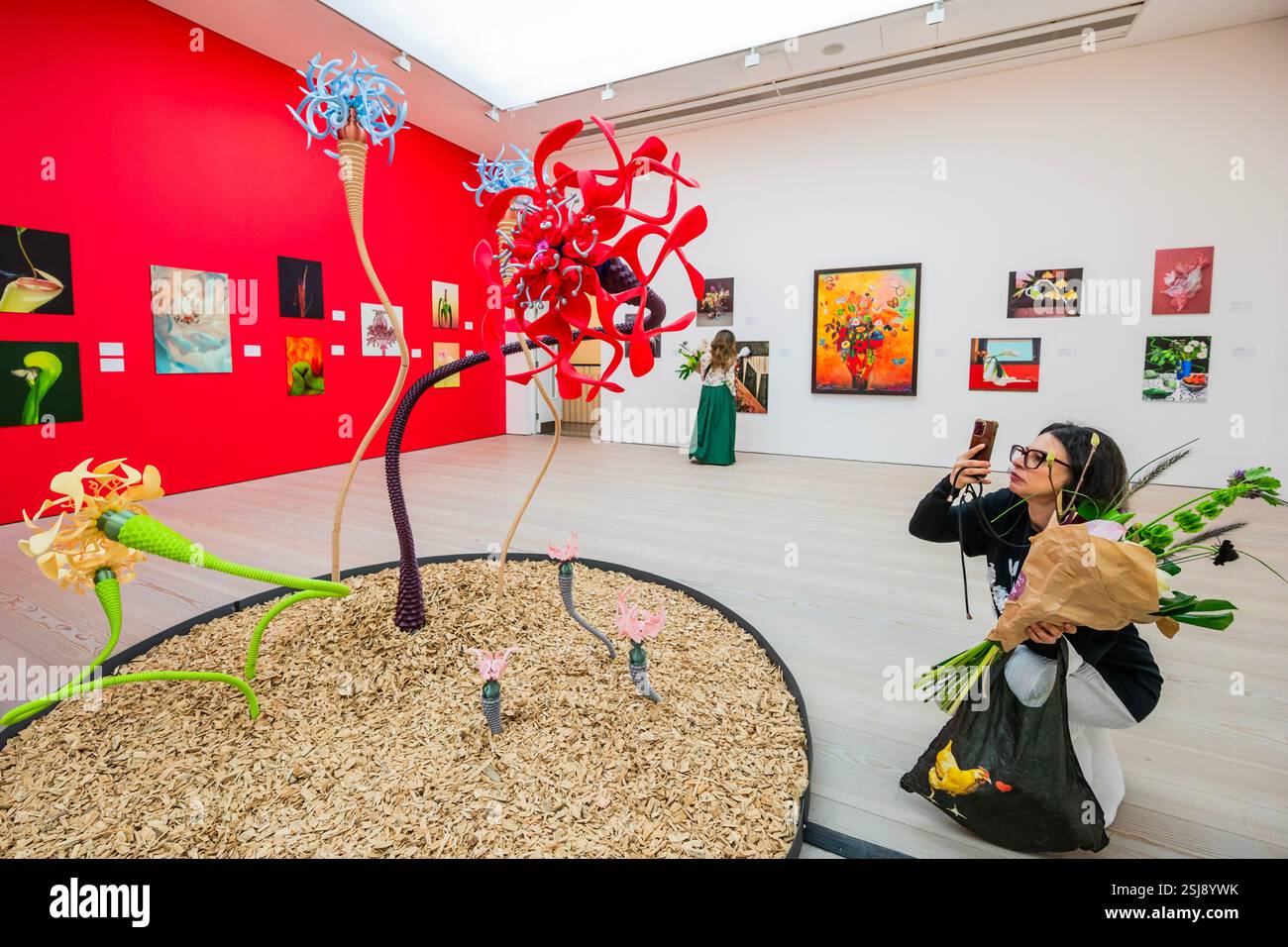London, Großbritannien. Februar 2025. Besucher, die Blumensträuße erhalten haben, bewundern das ...