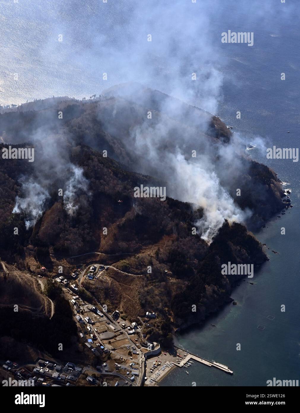 An aerial photo shows a forest fire, continues to spread in Ofunato ...