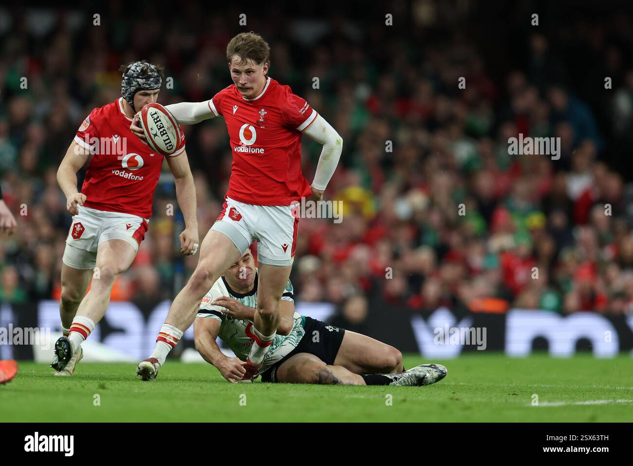 Cardiff, Großbritannien. Februar 2025. Ellis Mee aus Wales macht eine Pause hinter James Lowe ...