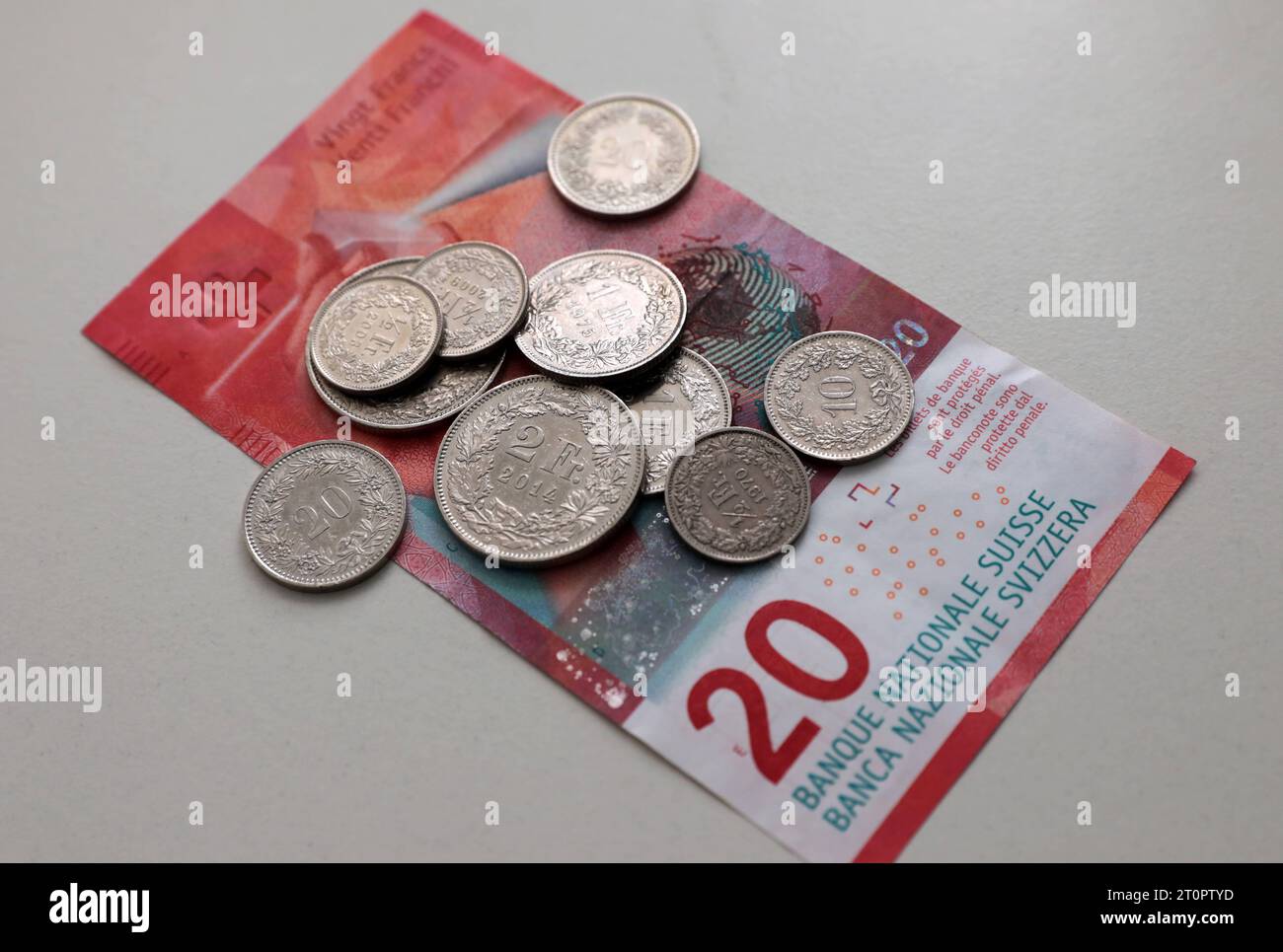 Ein 20-Franken Geldschein und verschiedene Münzen, Währung jeweils in ...