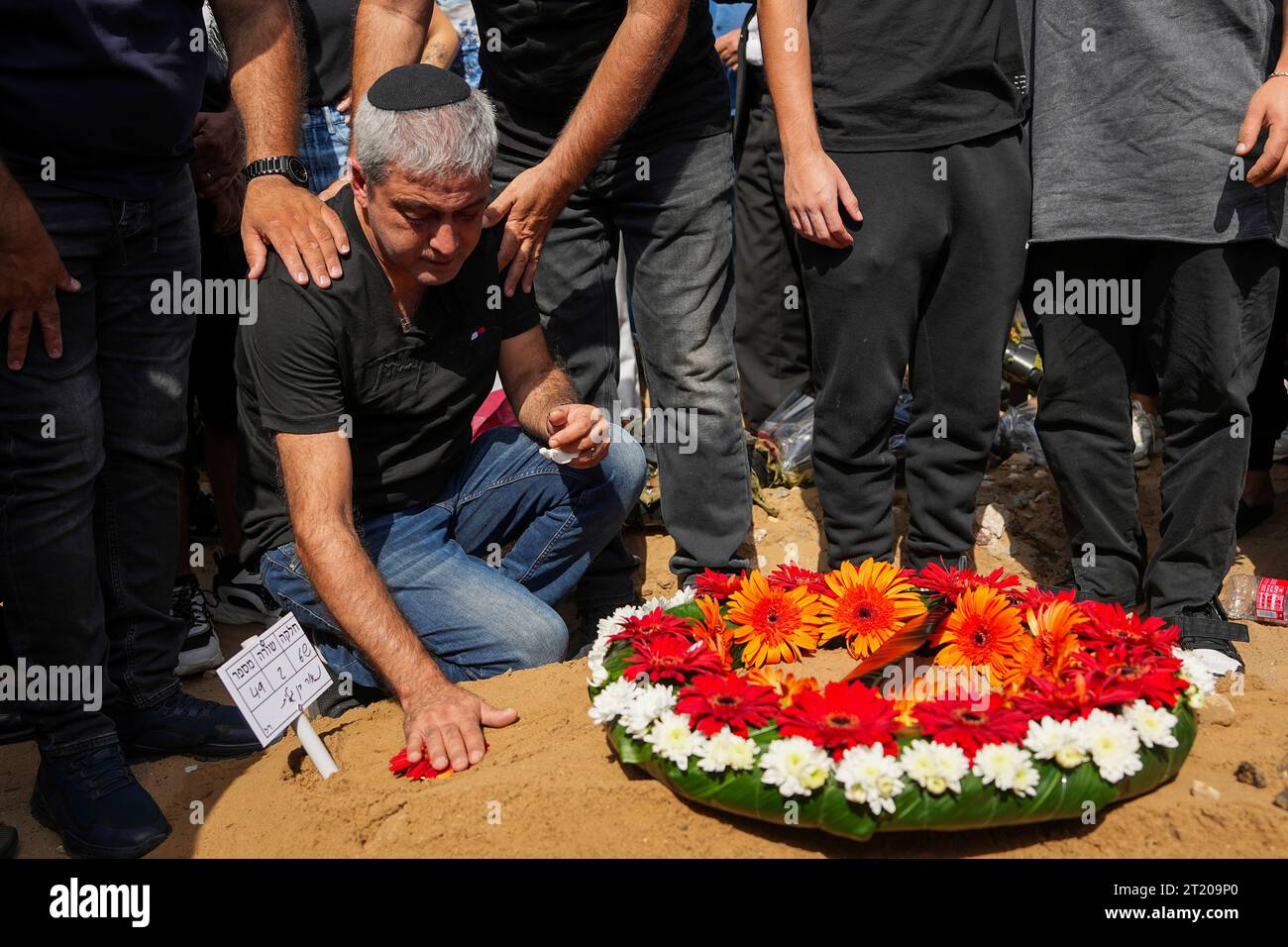 Father of Naor Hassidim grieves over his son's grave, during his ...
