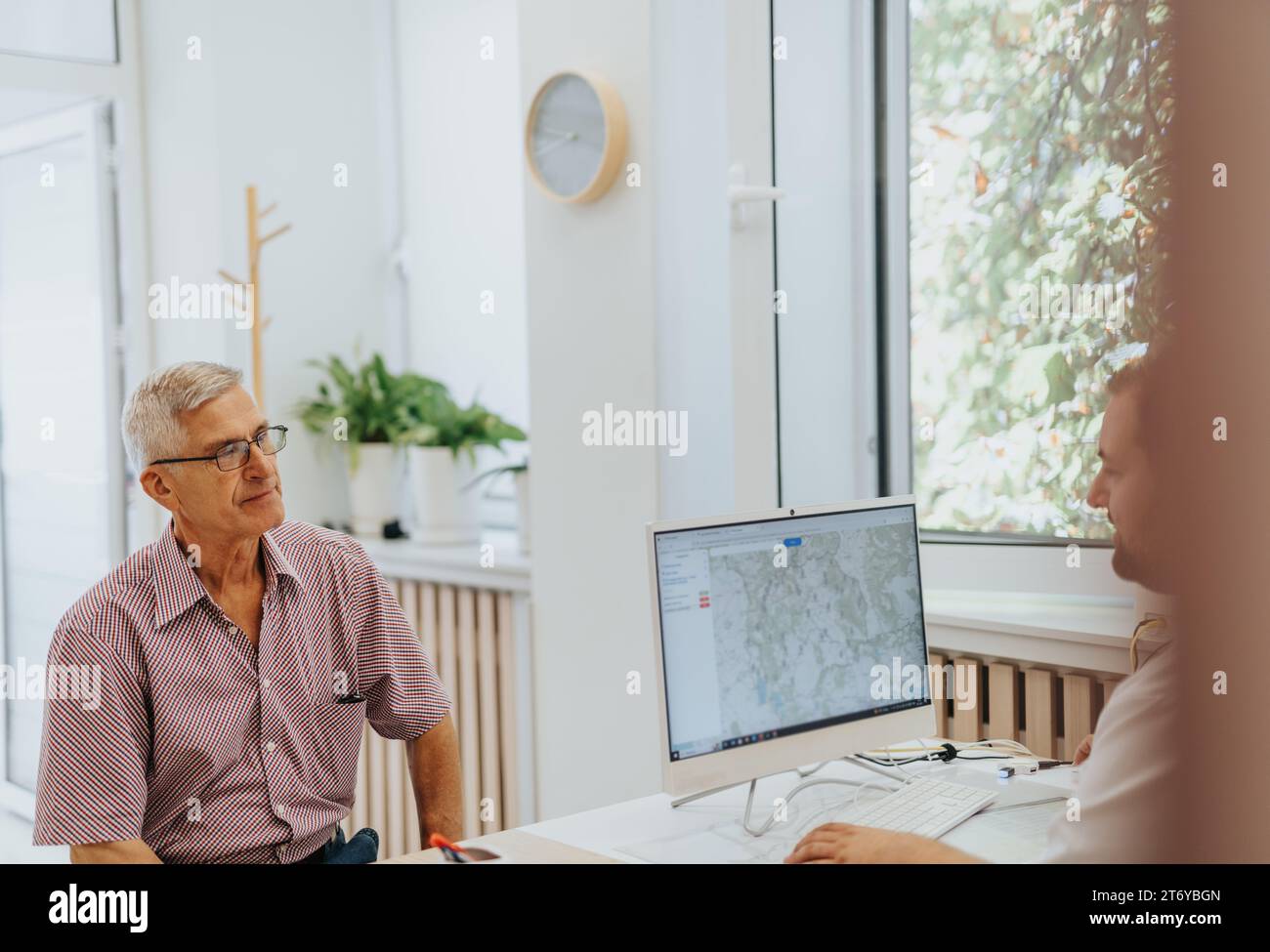 Ein professioneller Arzt analysiert ein Röntgenbild mit einem älteren ... Ein professioneller Arzt analysiert ein Röntgenbild mit einem älteren ...