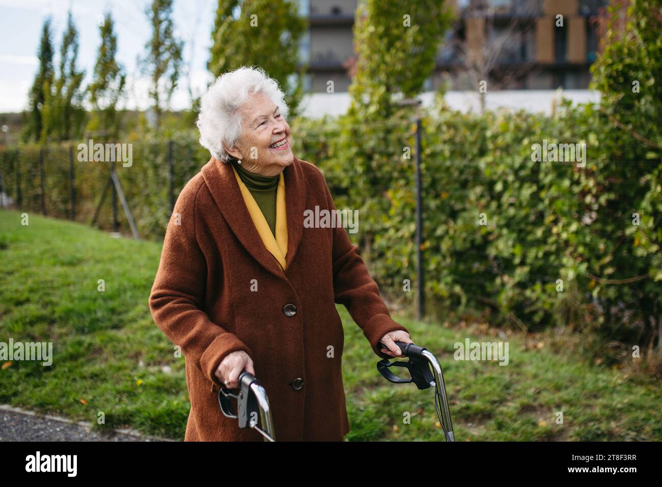 Seniorin mit einem Gehhilfen, der am Herbsttag auf den Straßen der ...