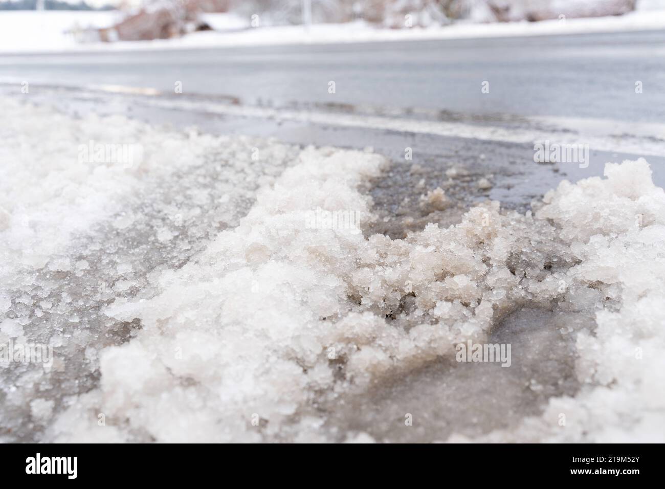 Bayern, Deutschland - 26. November 2023: Schnee und Eis auf einer Straße. Rutschige Straße ...