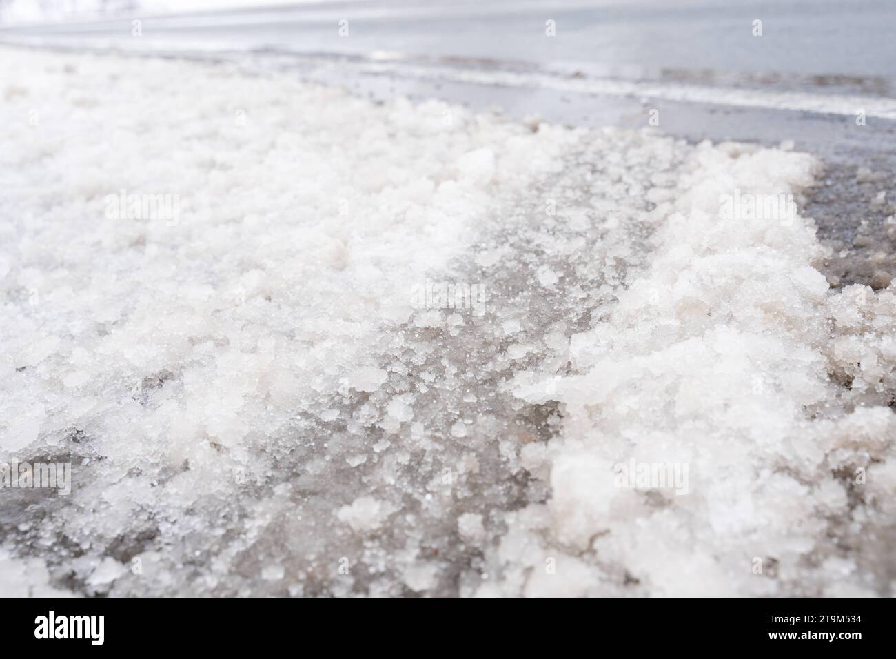 Bayern, Deutschland - 26. November 2023: Schnee und Eis auf einer Straße. Rutschige Straße ...